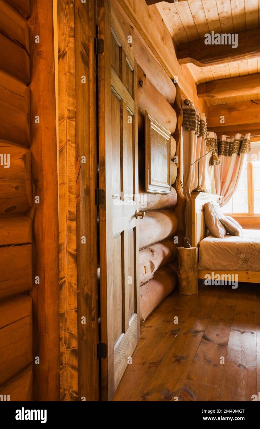 Opened door leading to master bedroom with cut tree trunk bedside table ...