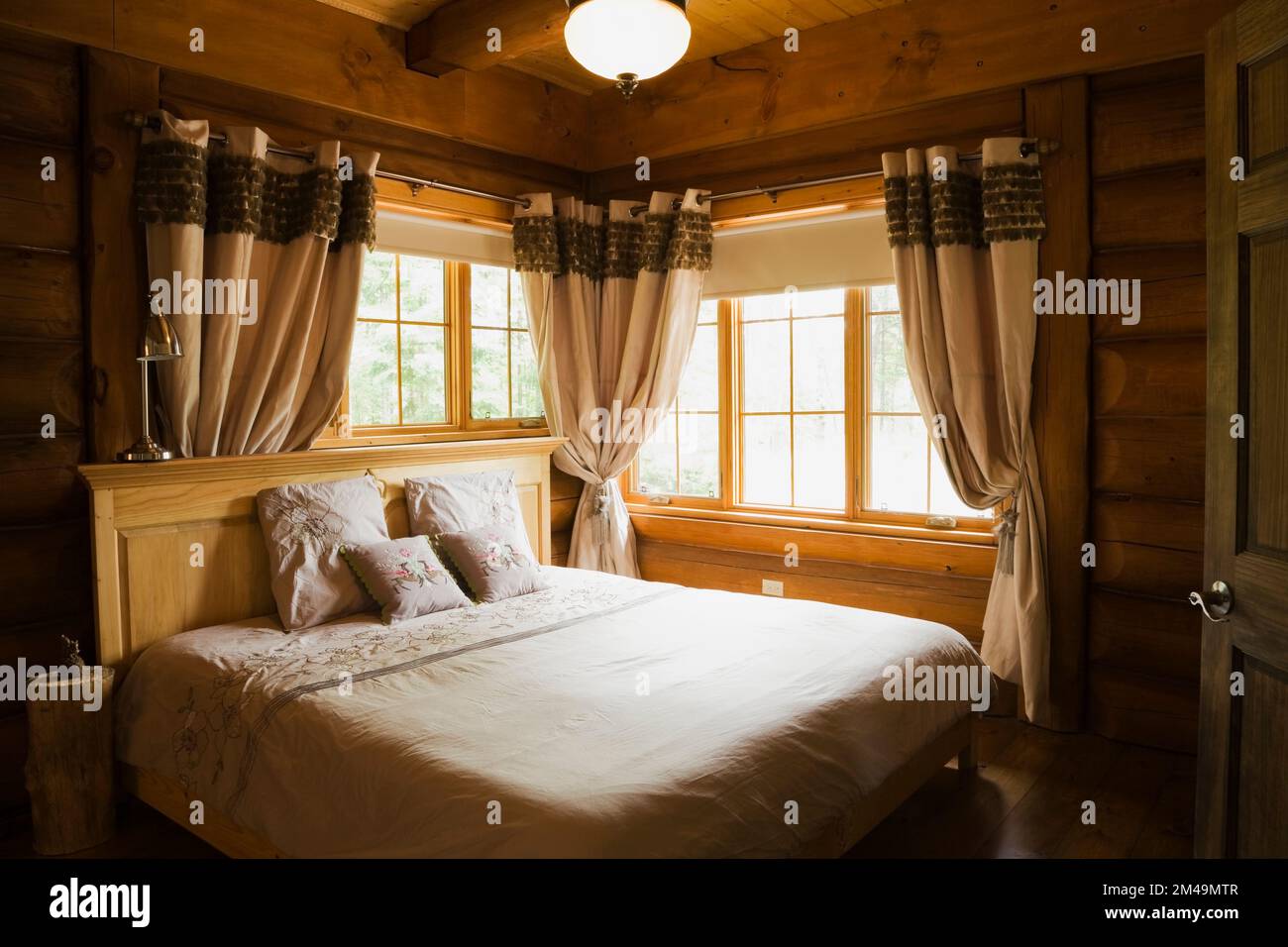 Wood frame double bed with wooden headboard in master bedroom inside ...