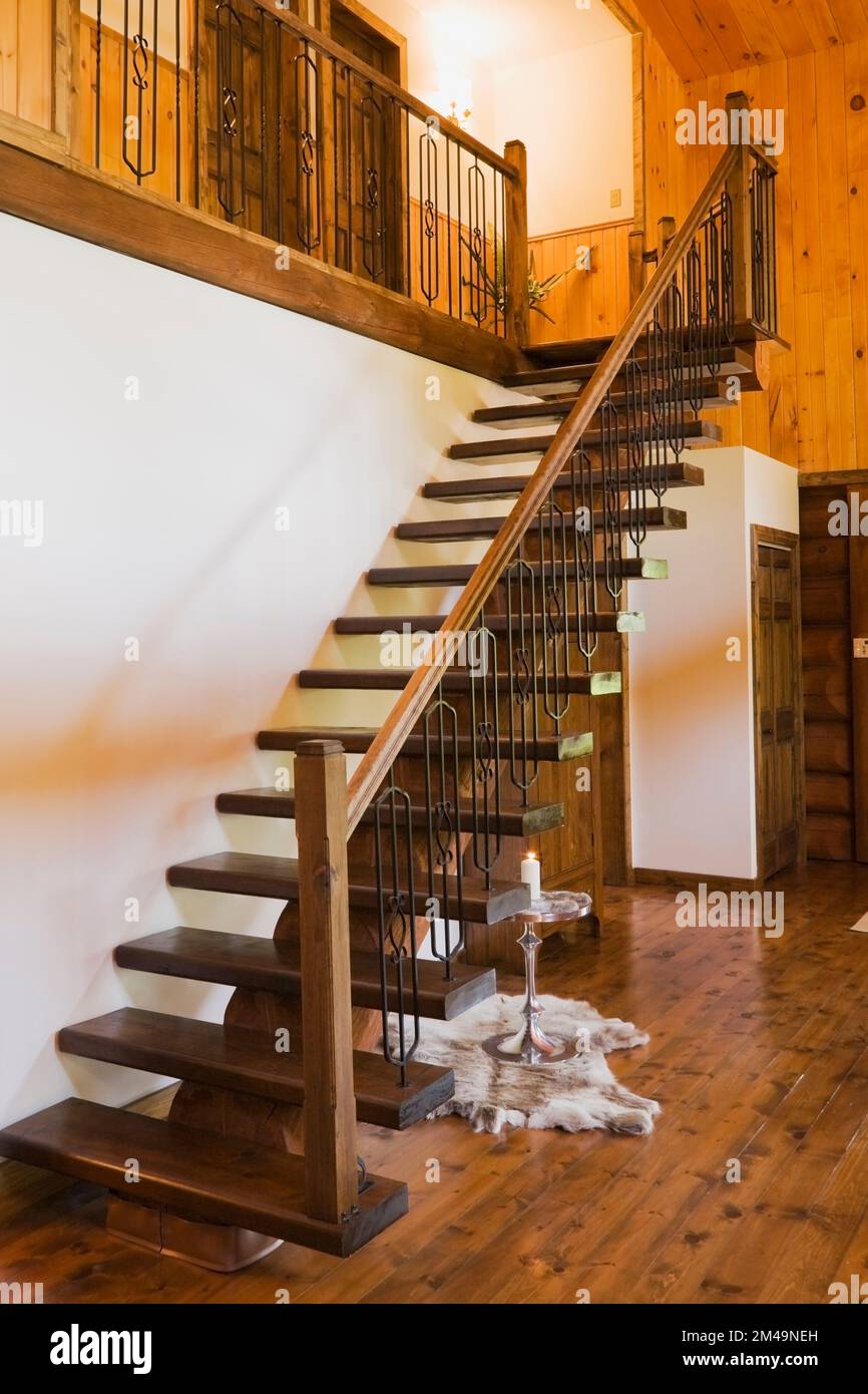 Wooden beam staircase leading to upstairs floor in hallway inside log ...