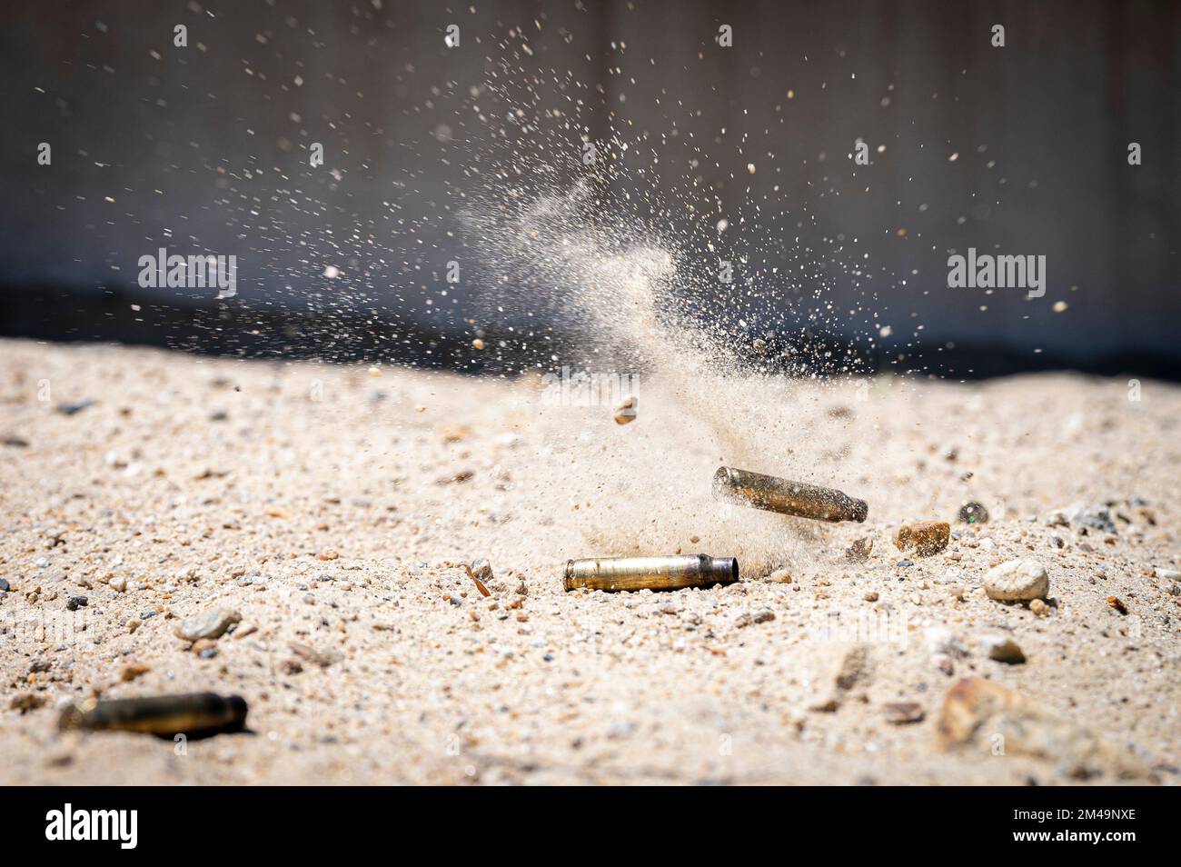 A 5.56mm shell casing hits the ground after being ejected from a ...