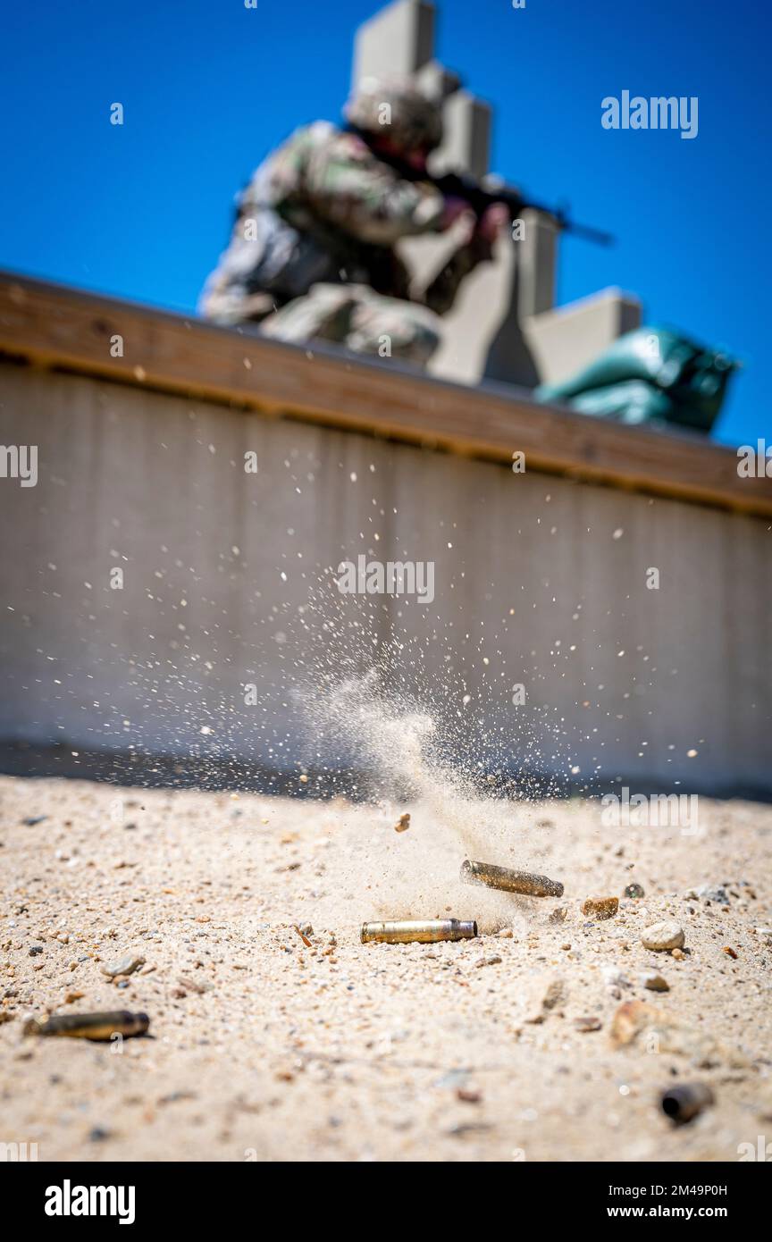 A 5.56mm shell casing hits the ground after being ejected from a ...