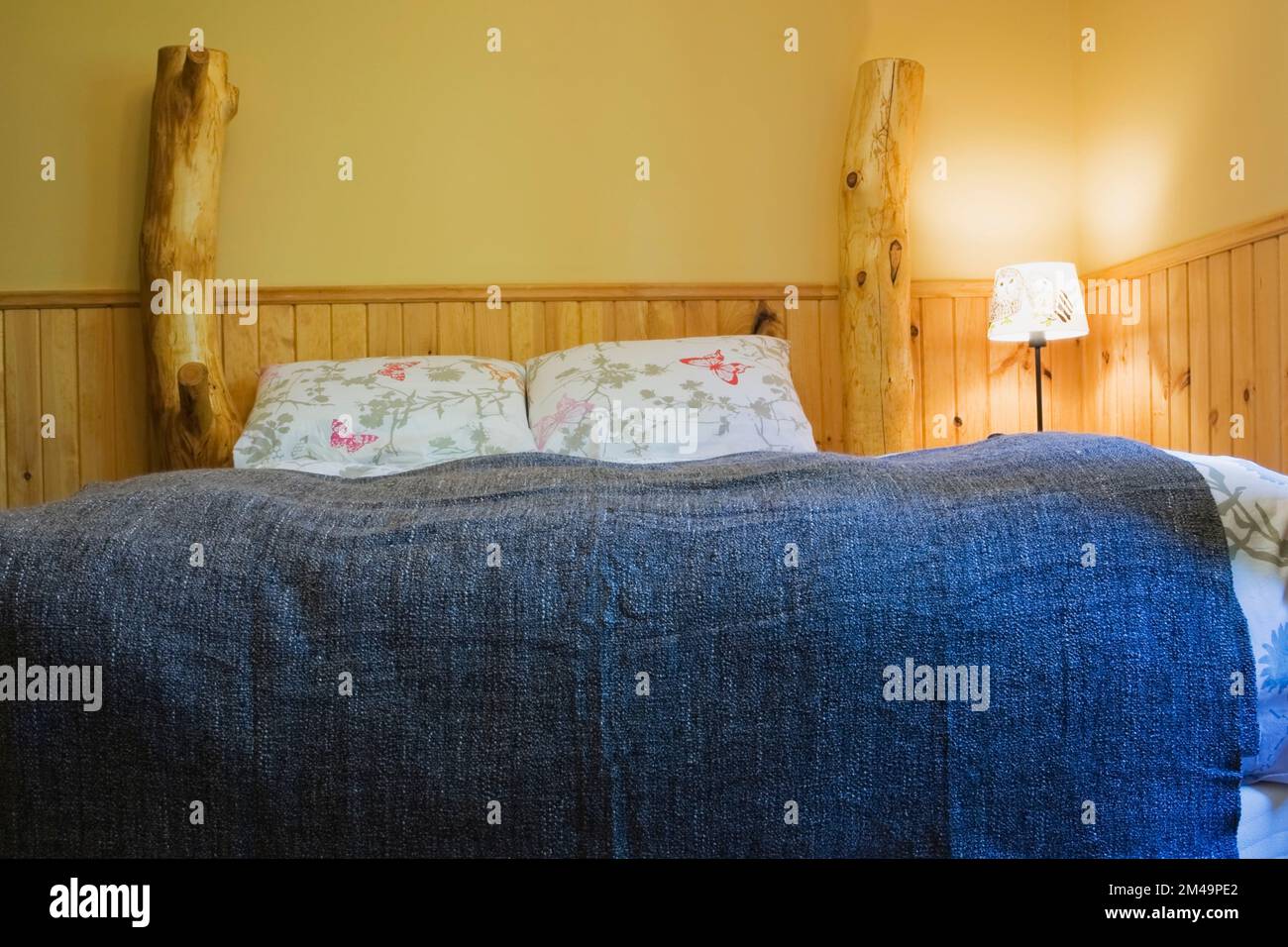 Rustic four poster bed covered with blue denim bedspread in upstairs ...
