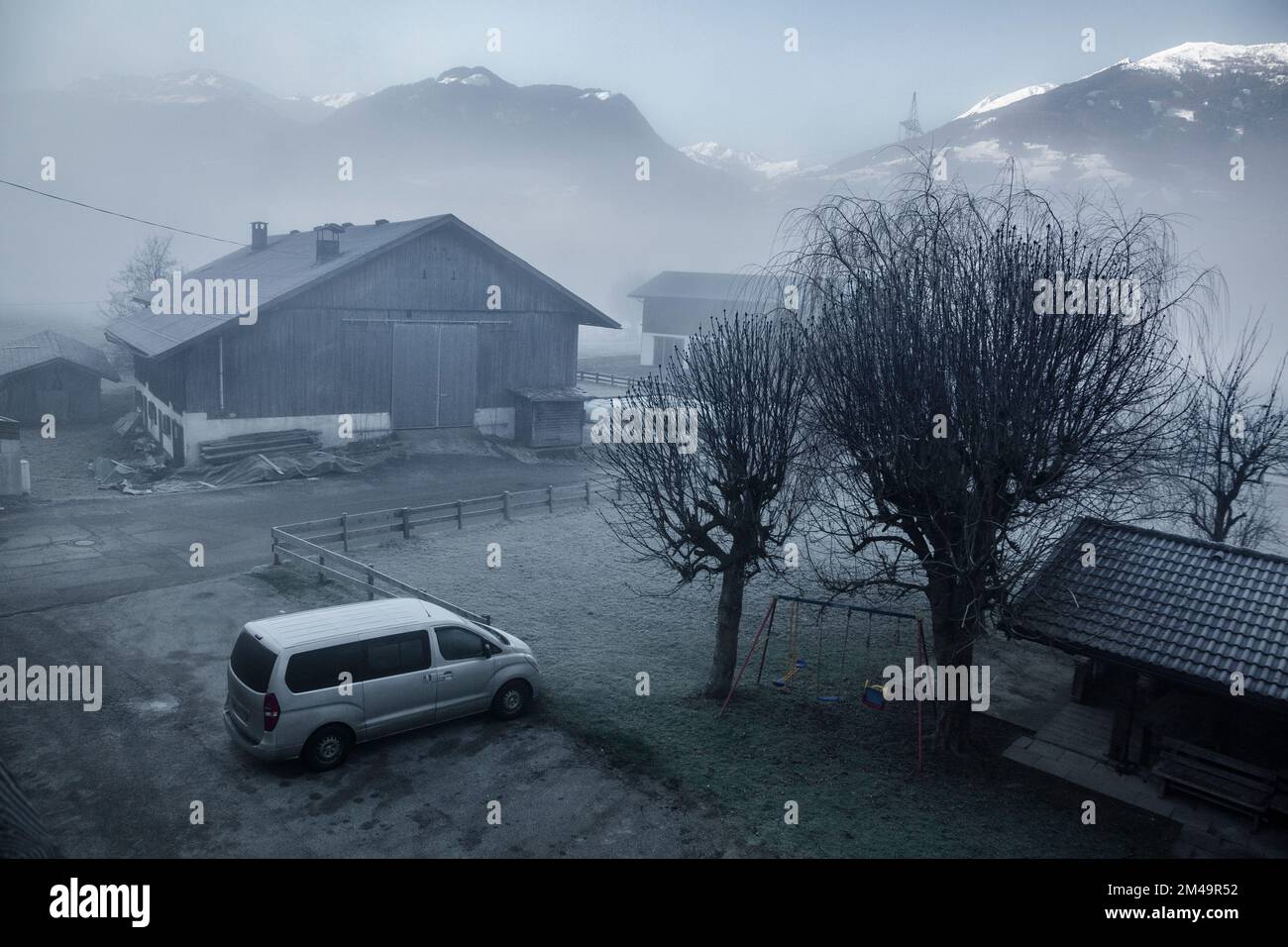 a farm in the Austrian mountains is covered in thick fog, Tyrol, Alps ...