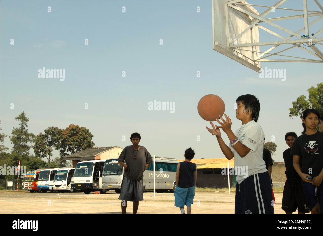 Teenagers playing basketball at a basketball field that occasionally ...