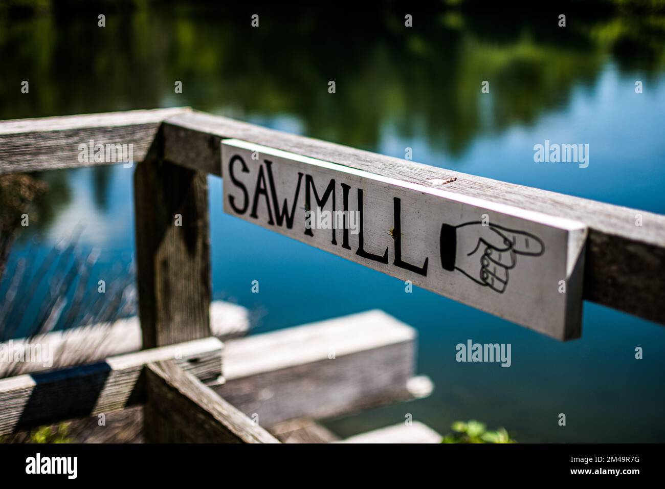 A closeup of the signboard with a "sawmill" writing and a hand sign ...