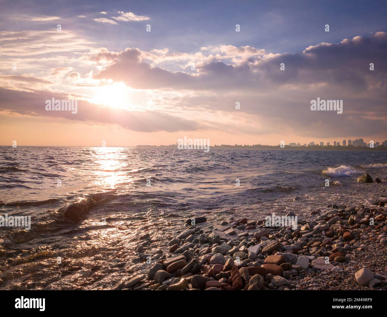 Autumn sunset view across a stretch of water with waves beating ...
