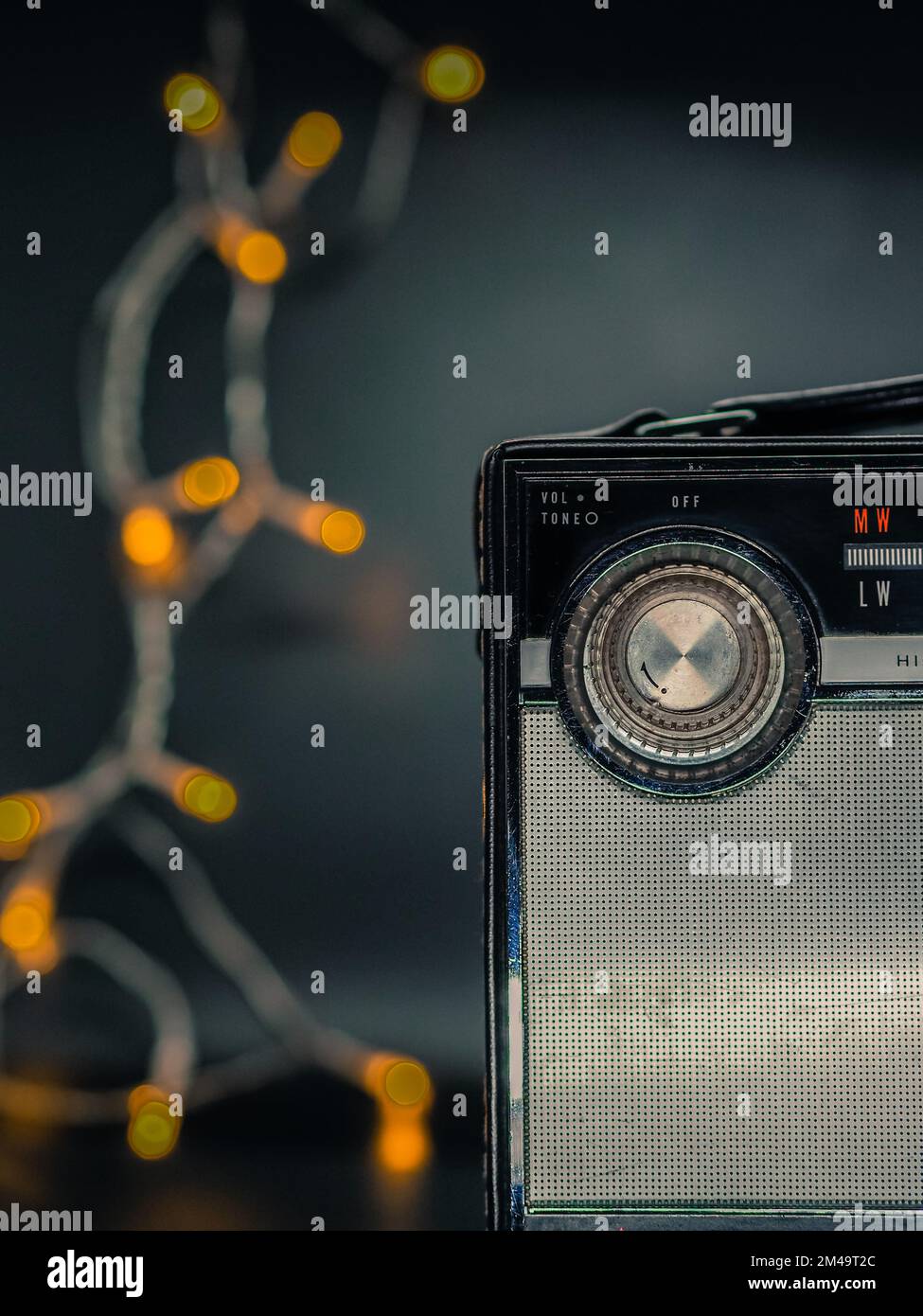 A vertical shot of a vintage transistor radio with glowing lights in ...
