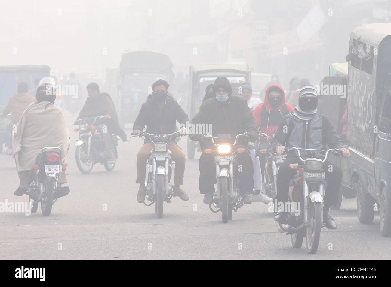 Lahore. 19th Dec, 2022. Vehicles move on a road amid fog in Lahore ...