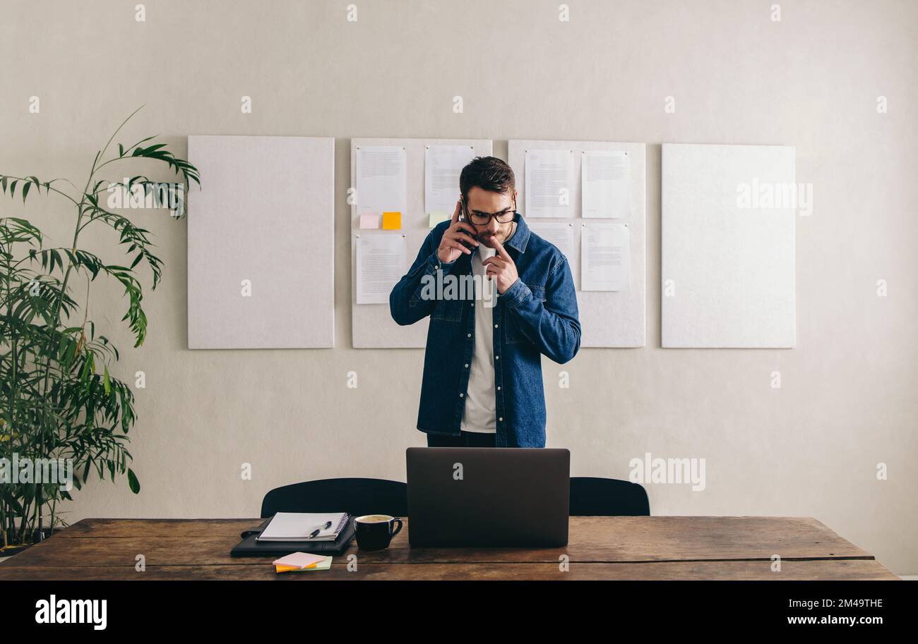 businessman with eyeglasses listening attentively during a phone call ...