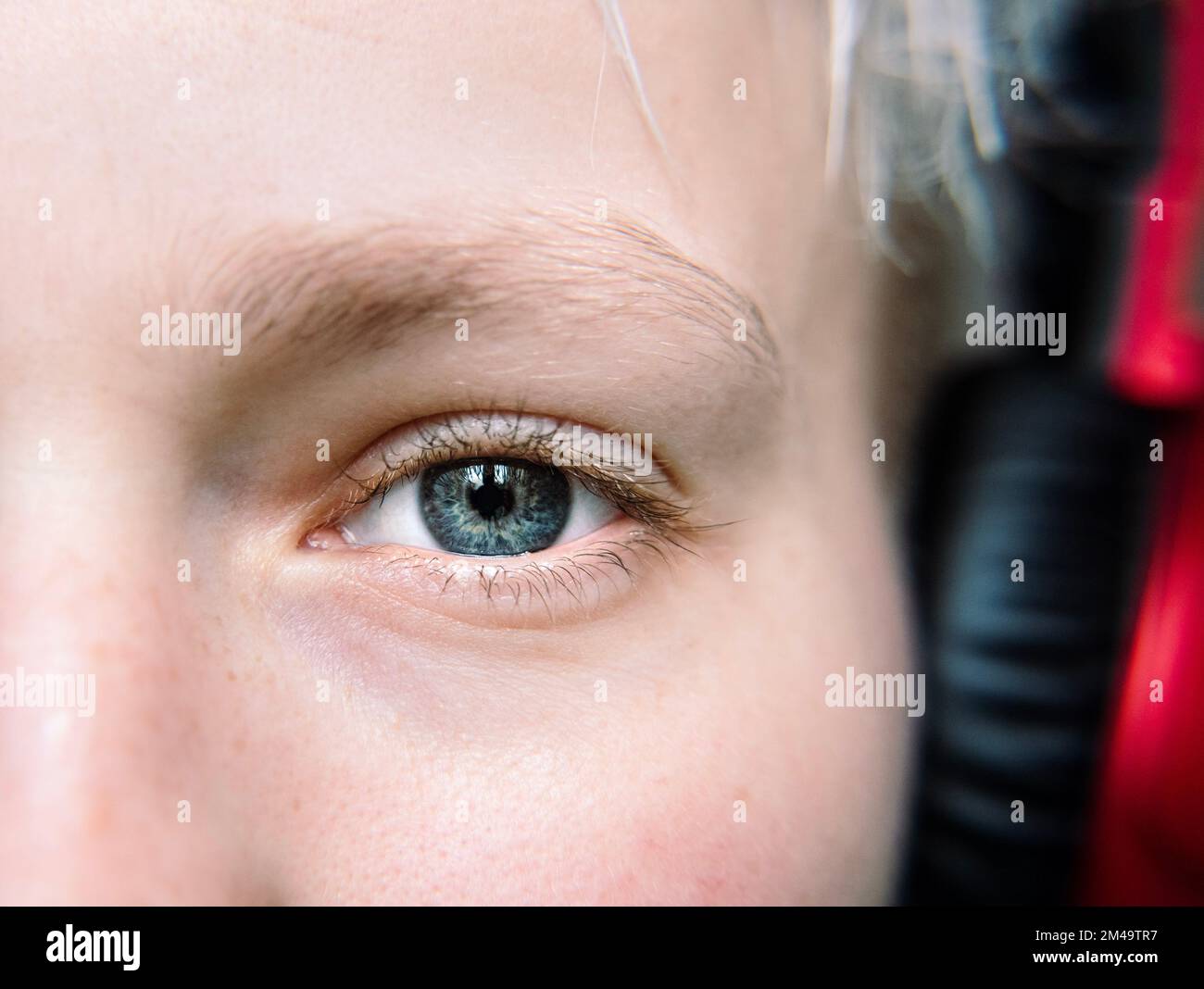 A human eye and headphones in a blurred background Stock Photo - Alamy