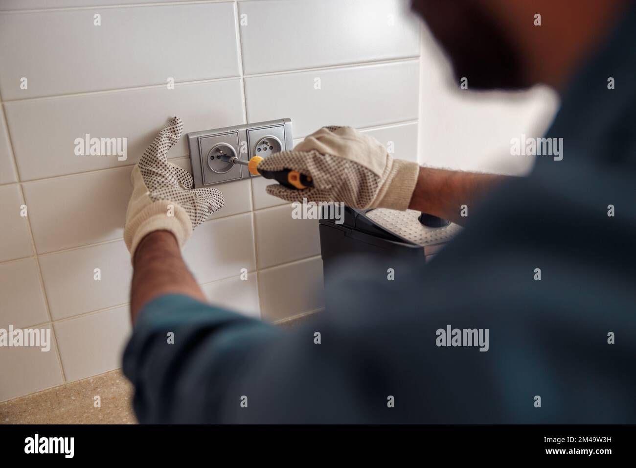 Close up of professional electrician worker with screwdriver is ...