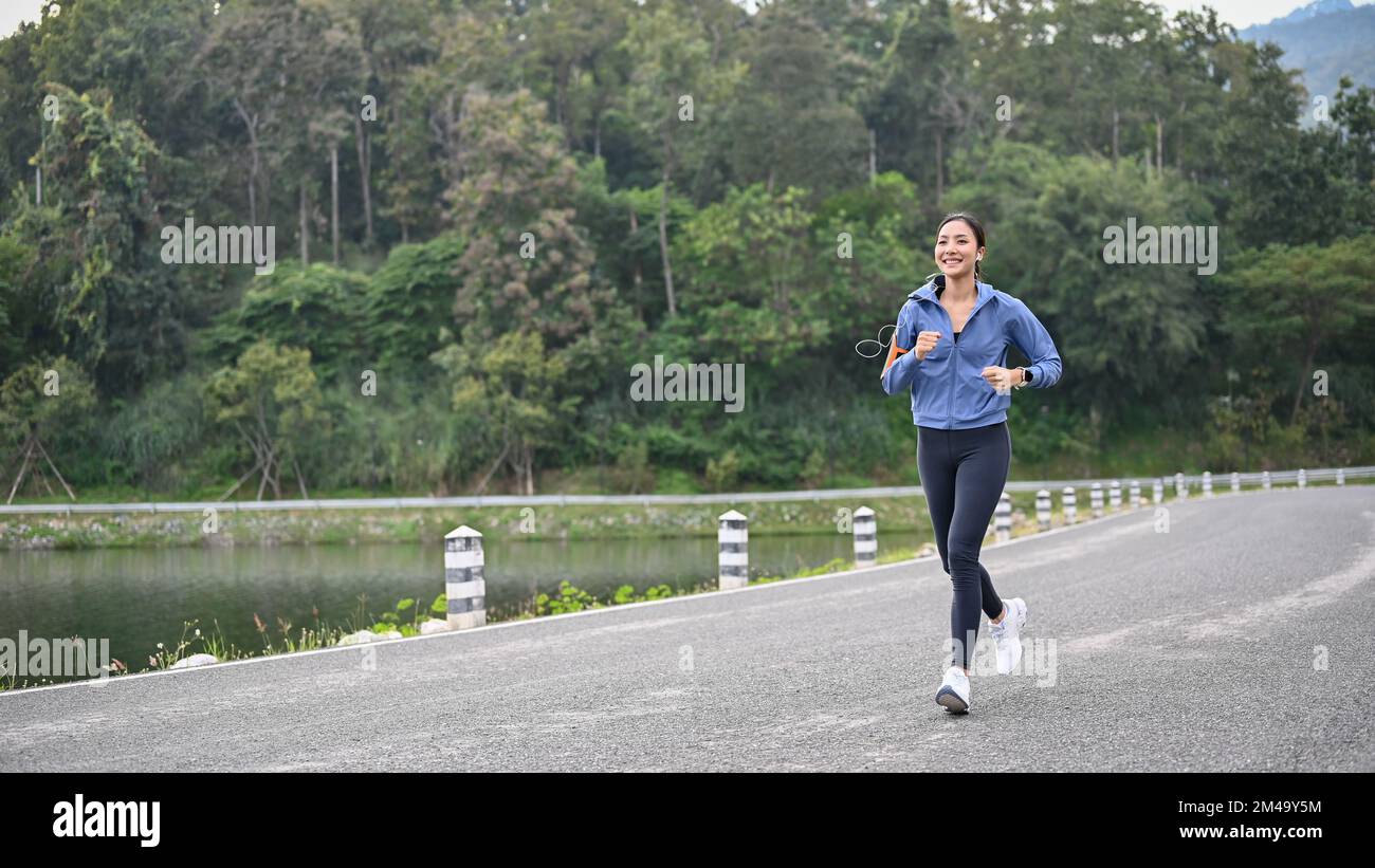 Sporty and active millennial Asian female jogger or runner in ...