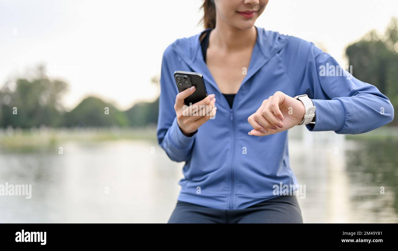 cropped image, Beautiful sporty Asian woman in sportswear checking her ...