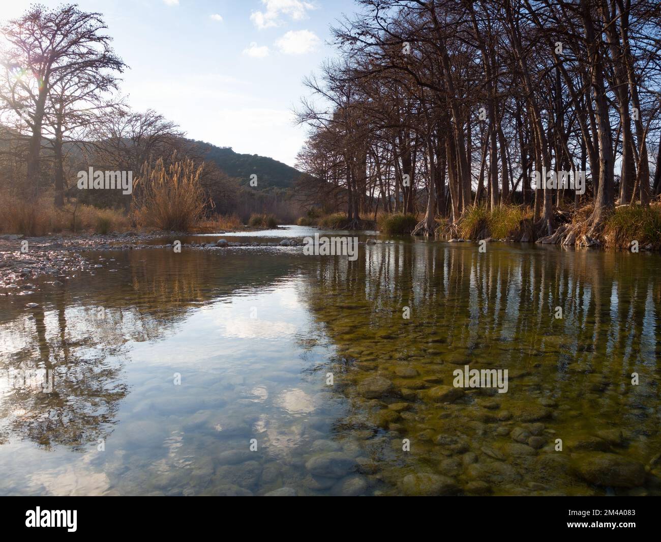 Low angle view over the clear Frio River with stones on riverbed and ...