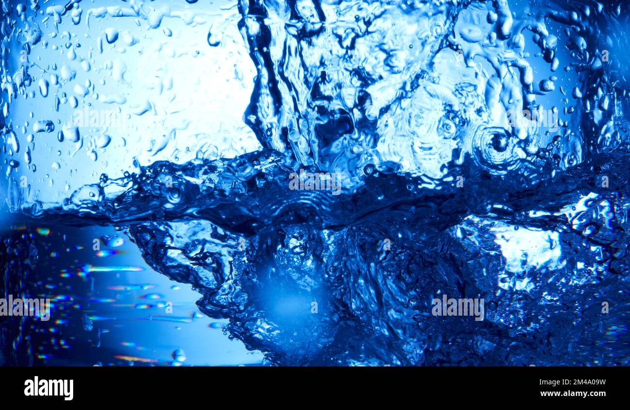 Drops of water falling into deep blue water Stock Photo - Alamy