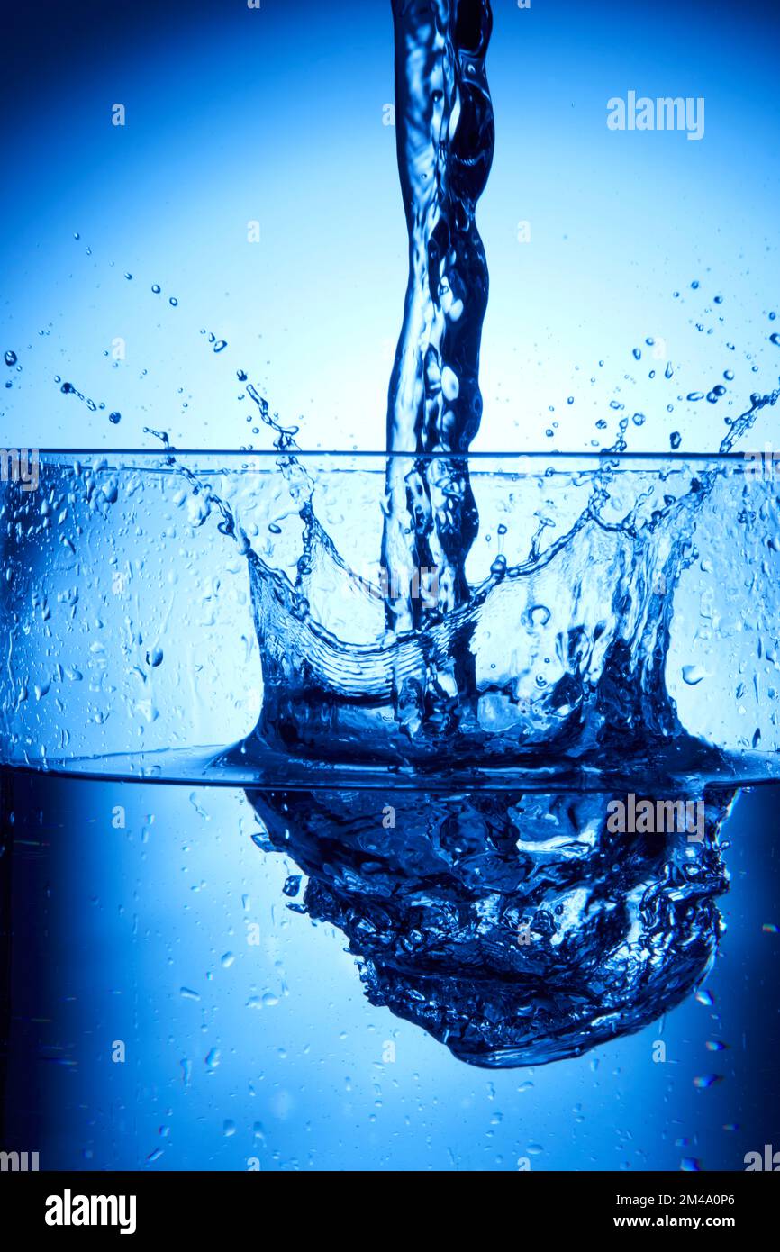 Drops of water falling into deep blue water Stock Photo - Alamy