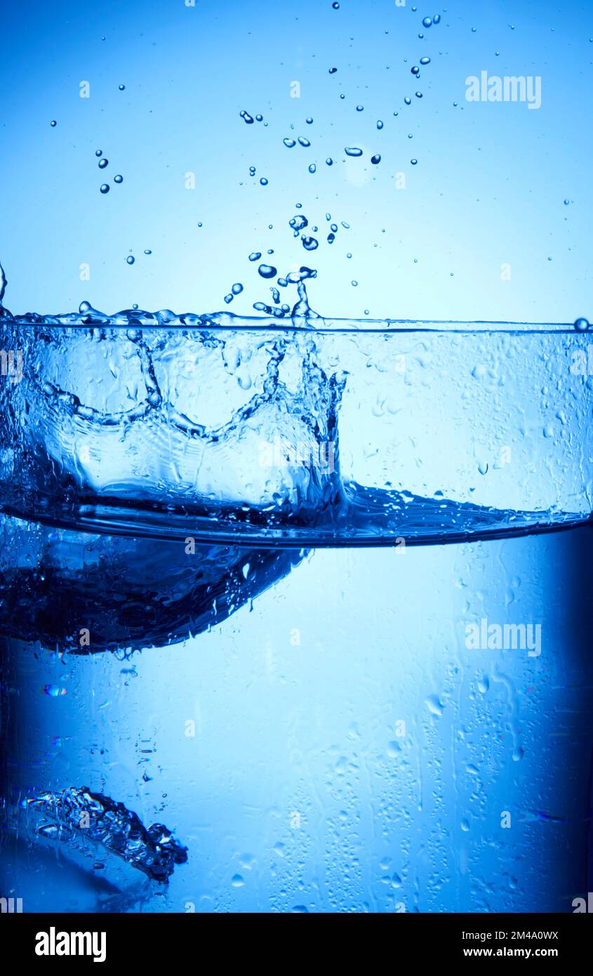 Drops of water falling into deep blue water Stock Photo - Alamy