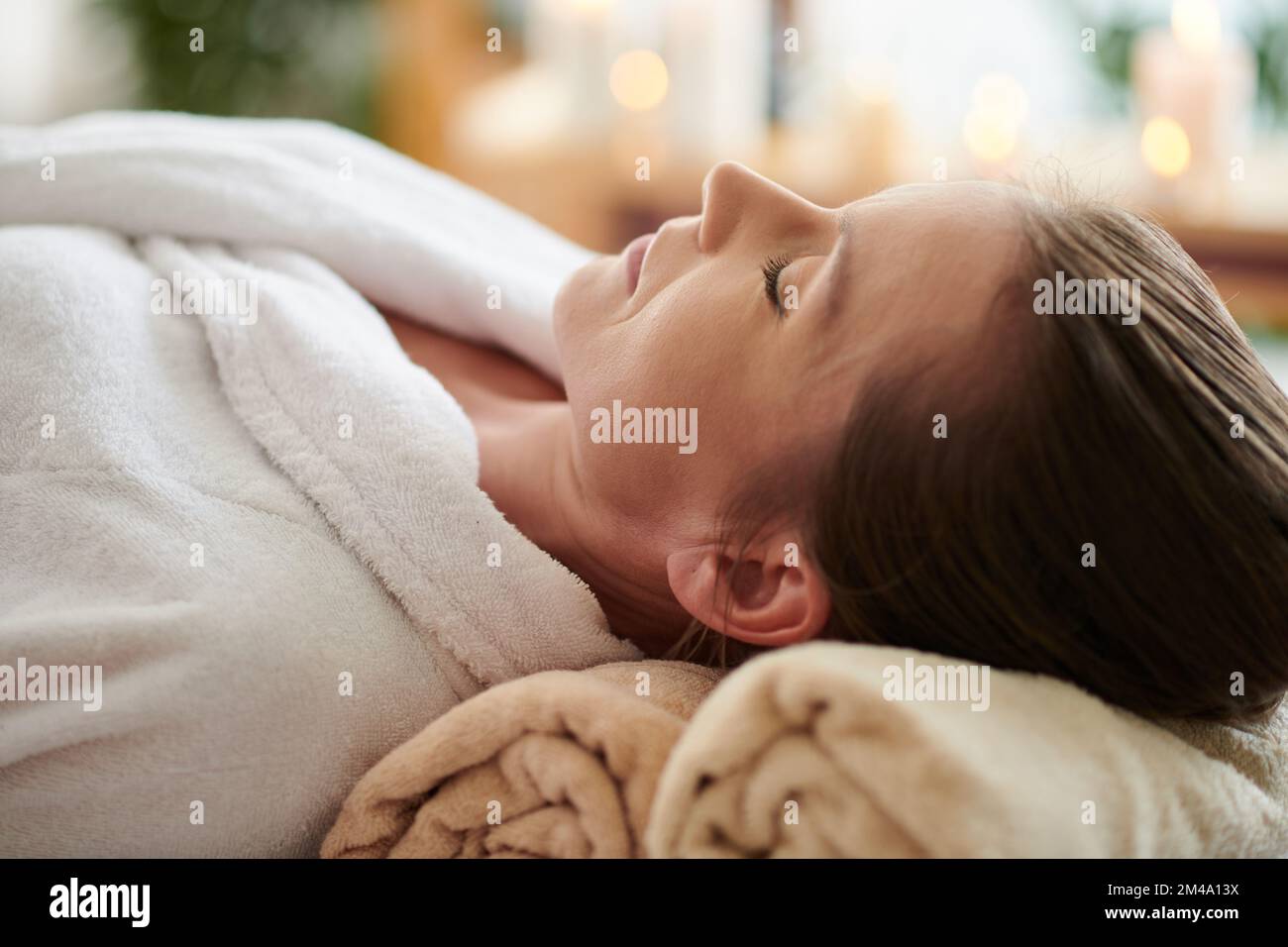 Mature woman in bathrobe relaxing in spa salon after body massage Stock ...