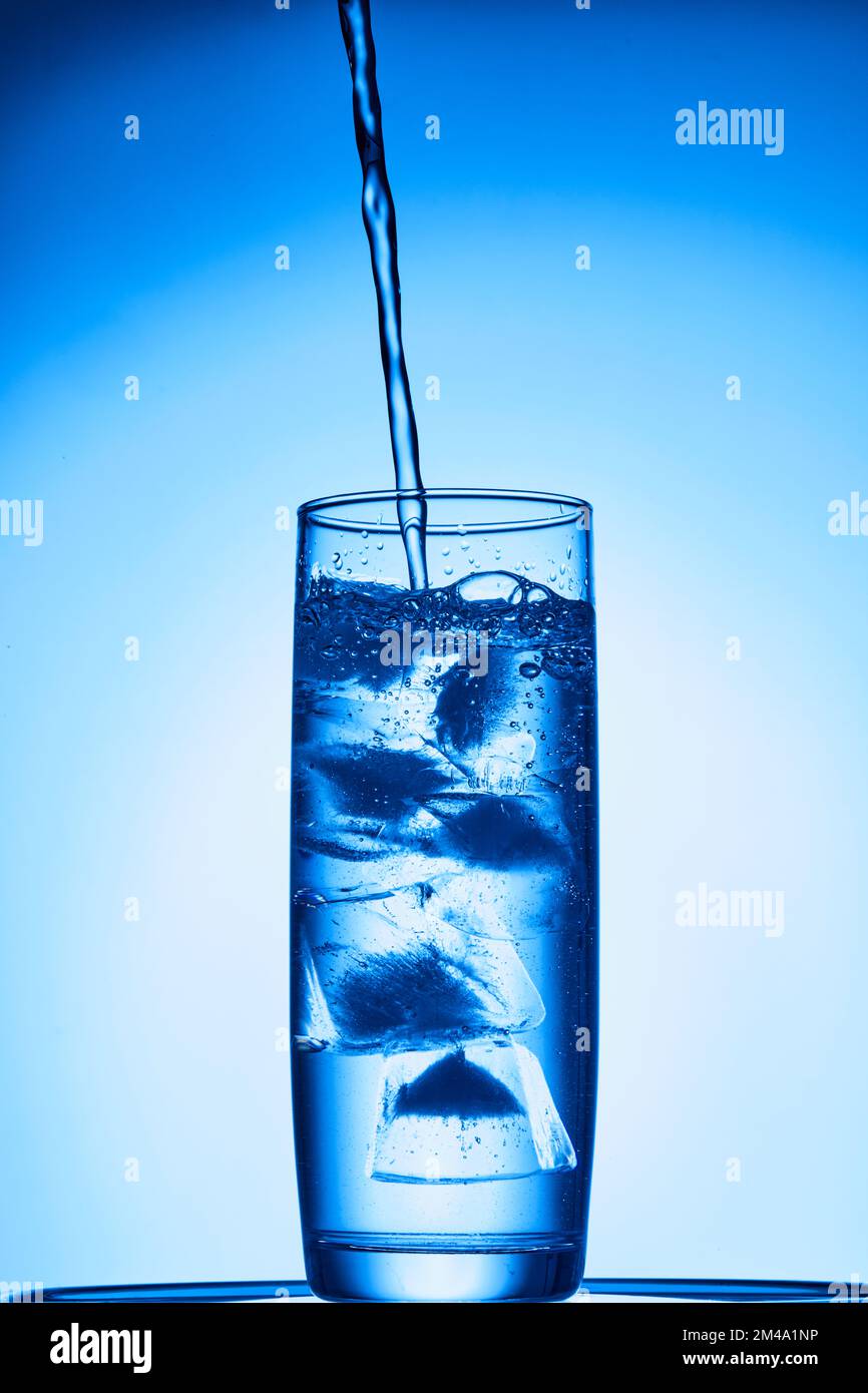 Drops of water falling into deep blue water Stock Photo - Alamy