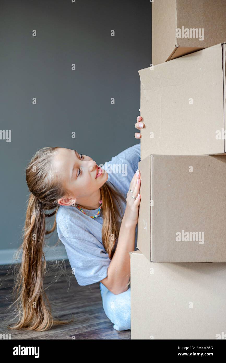 Happy girl moving in new house with cardboard boxes Stock Photo - Alamy