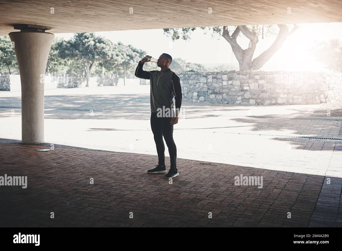 Staying hydrated. Full length shot of a handsome young man drinking ...