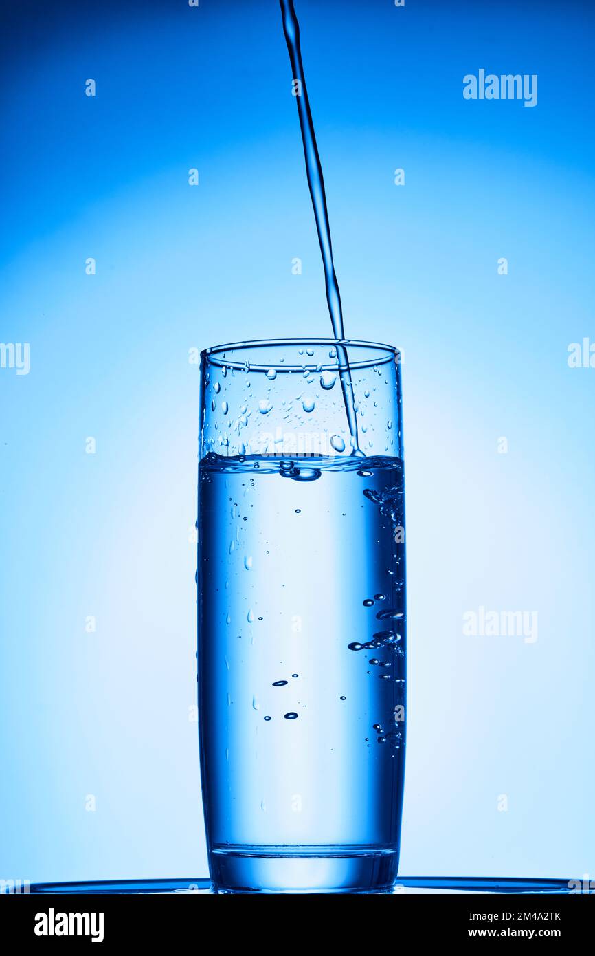Drops of water falling into deep blue water Stock Photo - Alamy
