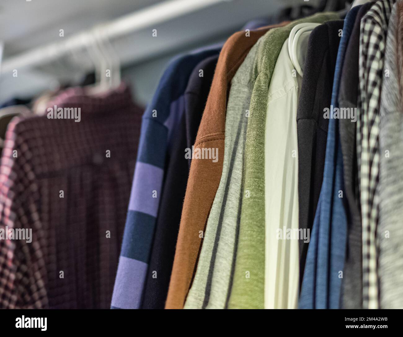 Mens wardrobe clothing hanging on rail in closet. Closeup photo of Men ...