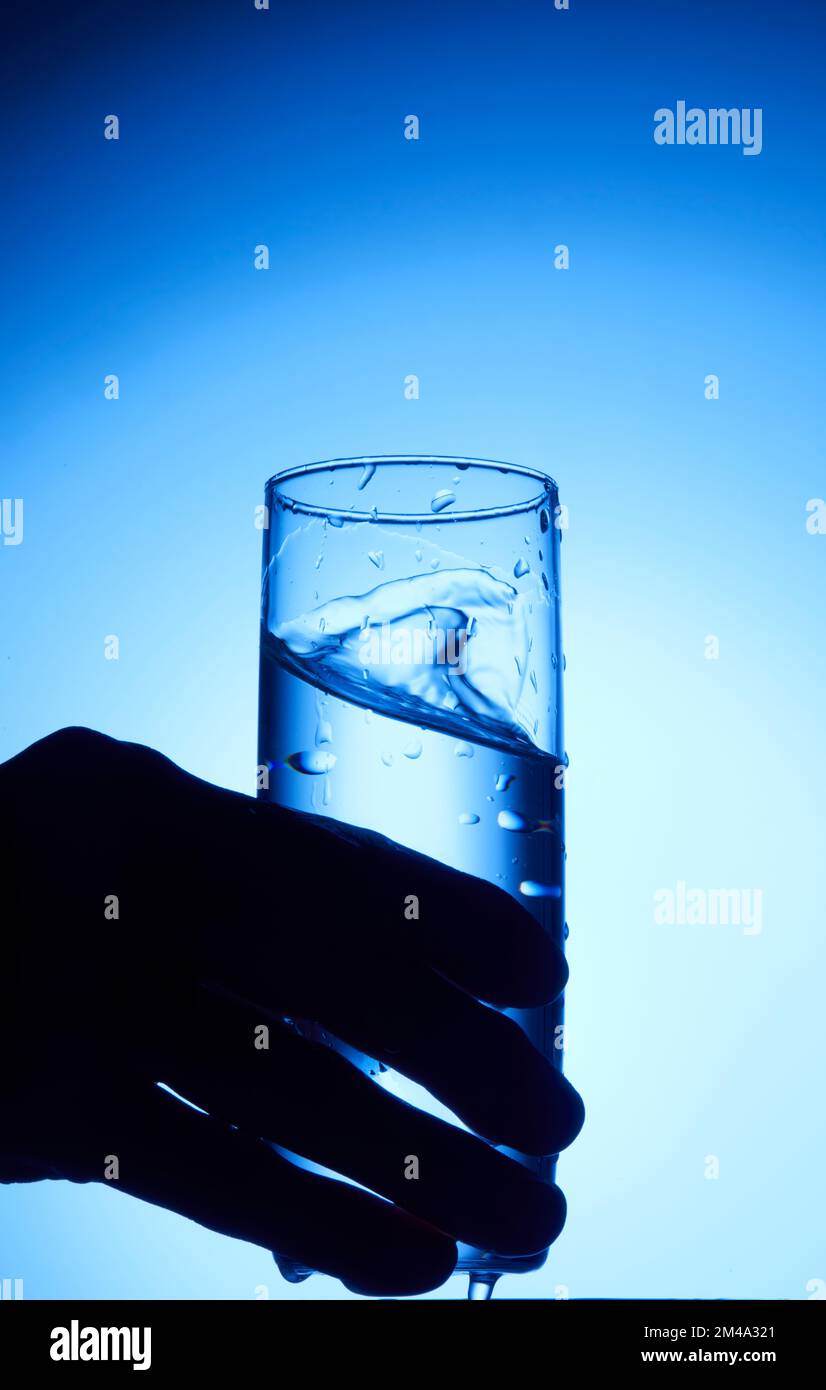 Drops of water falling into deep blue water Stock Photo - Alamy