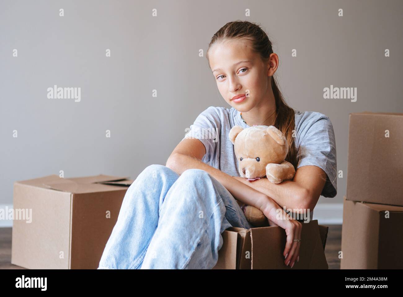Beautiful young girl moving in new house with cardboard boxes Stock ...