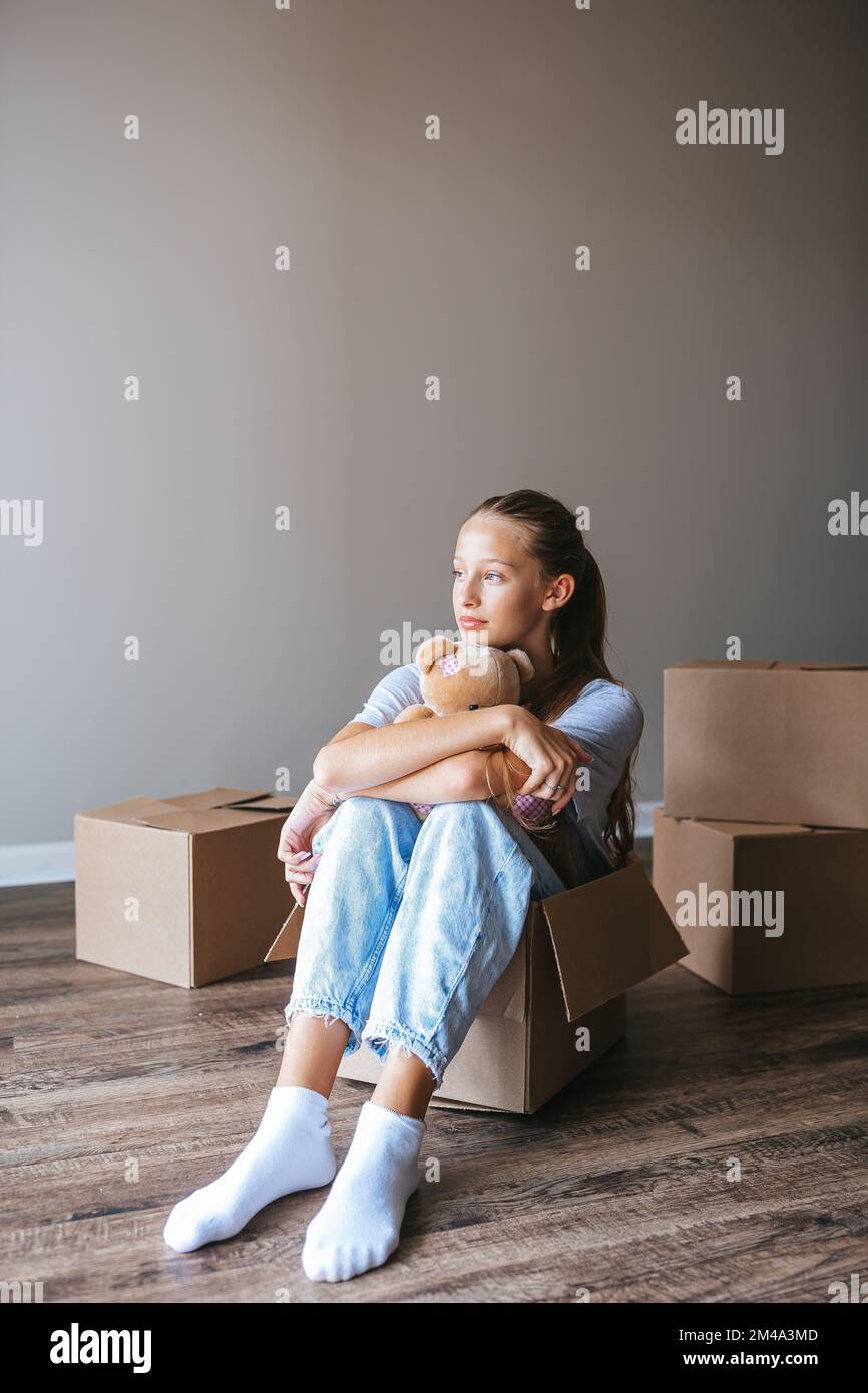 Beautiful young girl moving in new house with cardboard boxes Stock ...