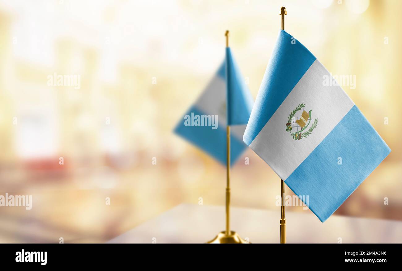 Small flags of the Guatemala on an abstract blurry background Stock ...