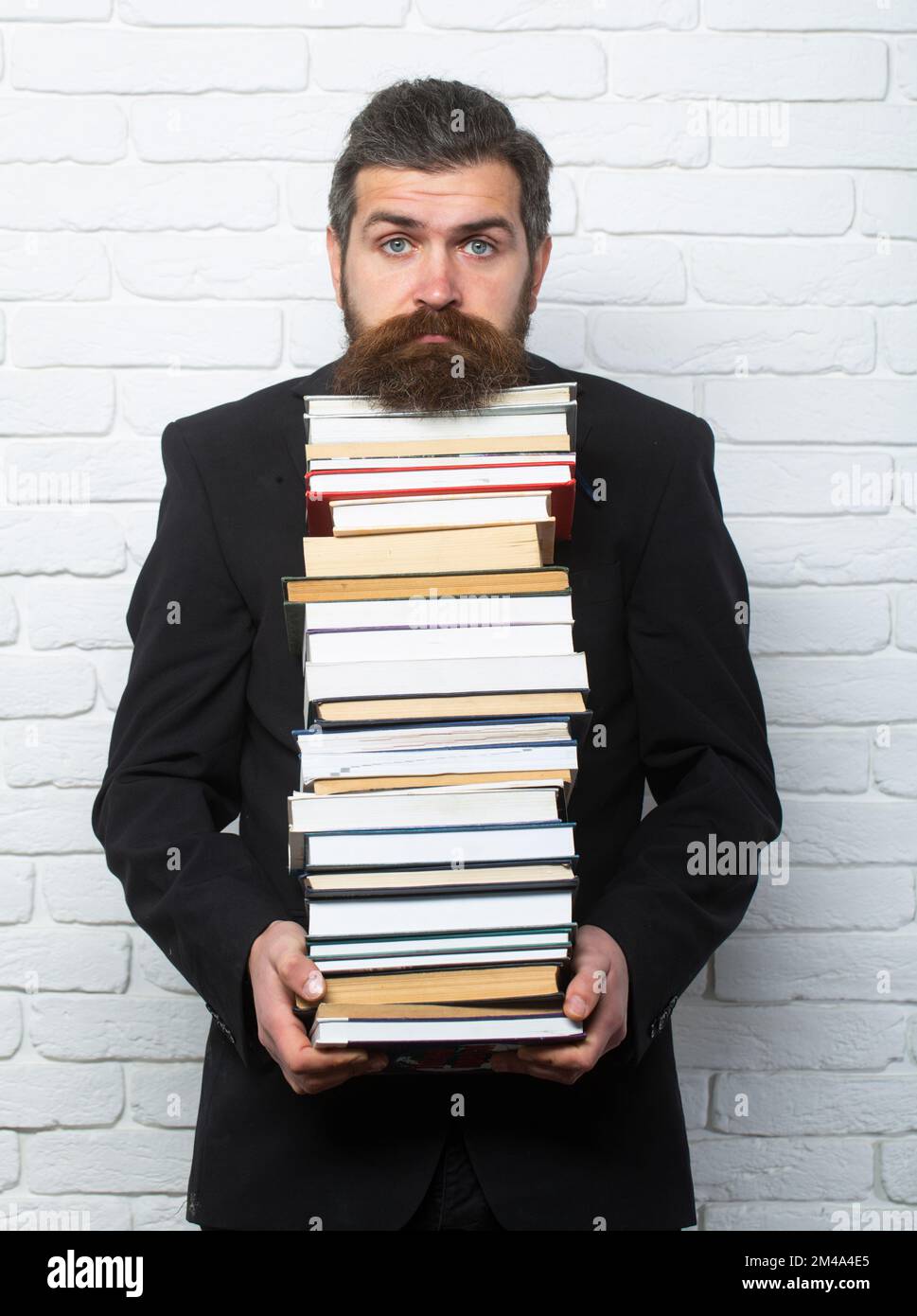 Portrait of a funny teacher or professor with book stack. Thinking ...