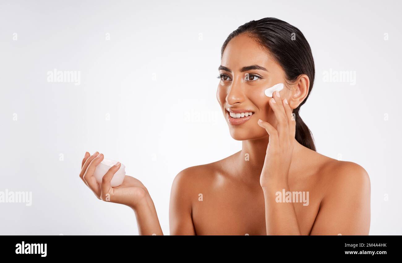 Taking care of her skin. Studio shot of a beautiful young woman ...