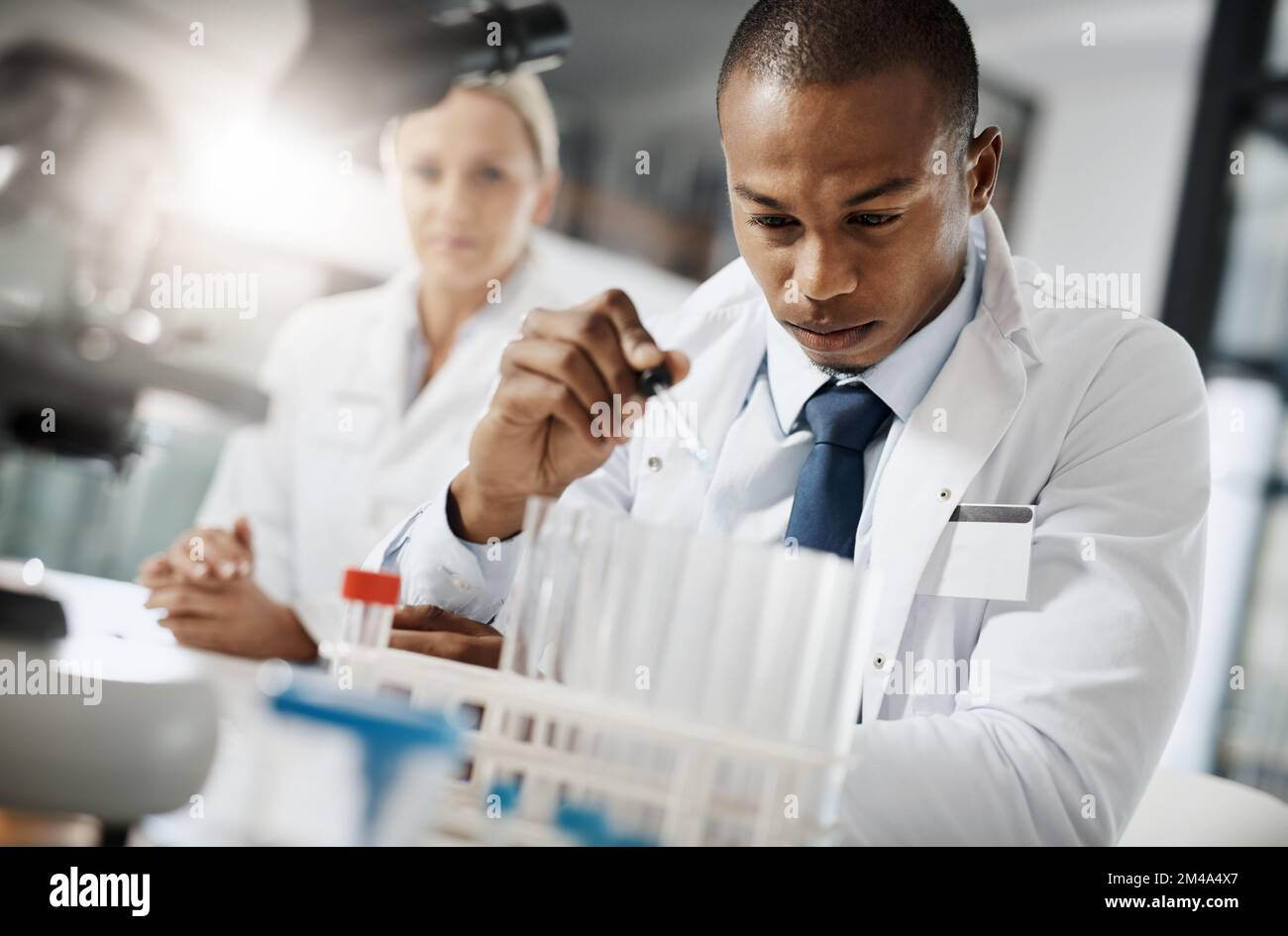 All in the name of medicine. a handsome young male scientist testing a ...