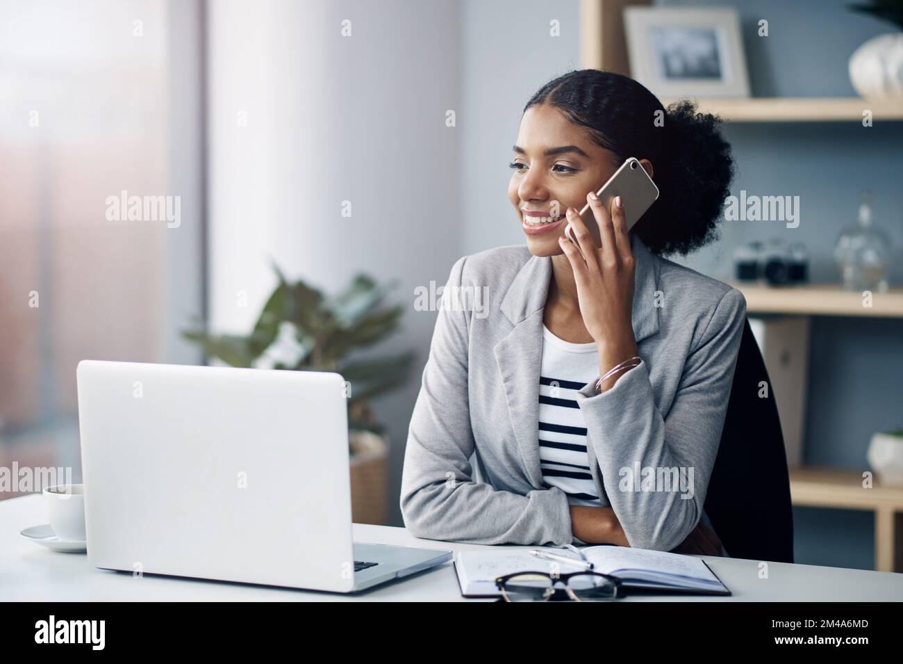 Success requires daily action. a young businesswoman using a smartphone ...