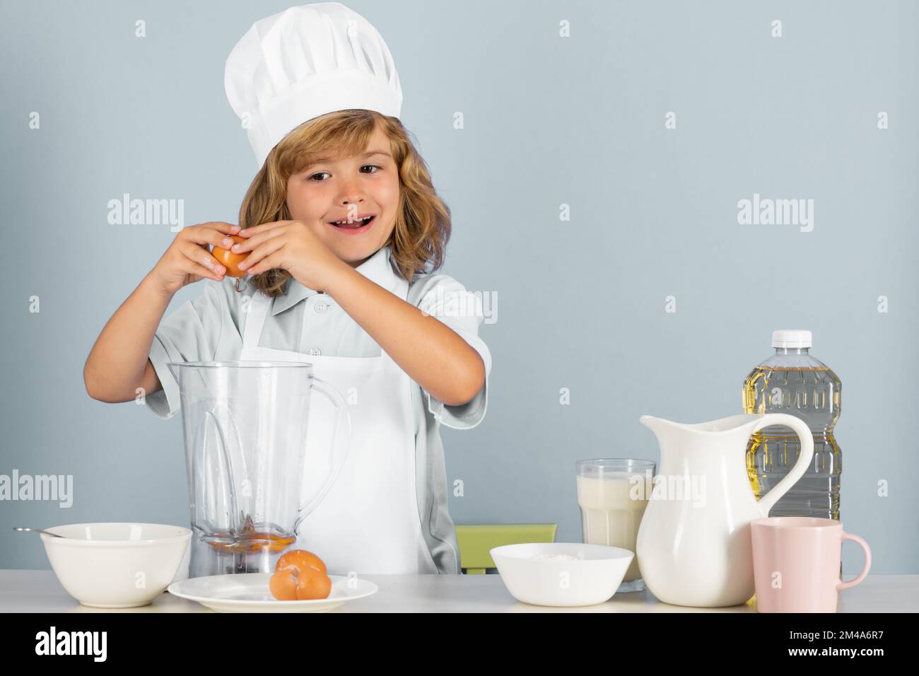 Child chef isolated on blue. Funny little kid chef cook wearing uniform ...