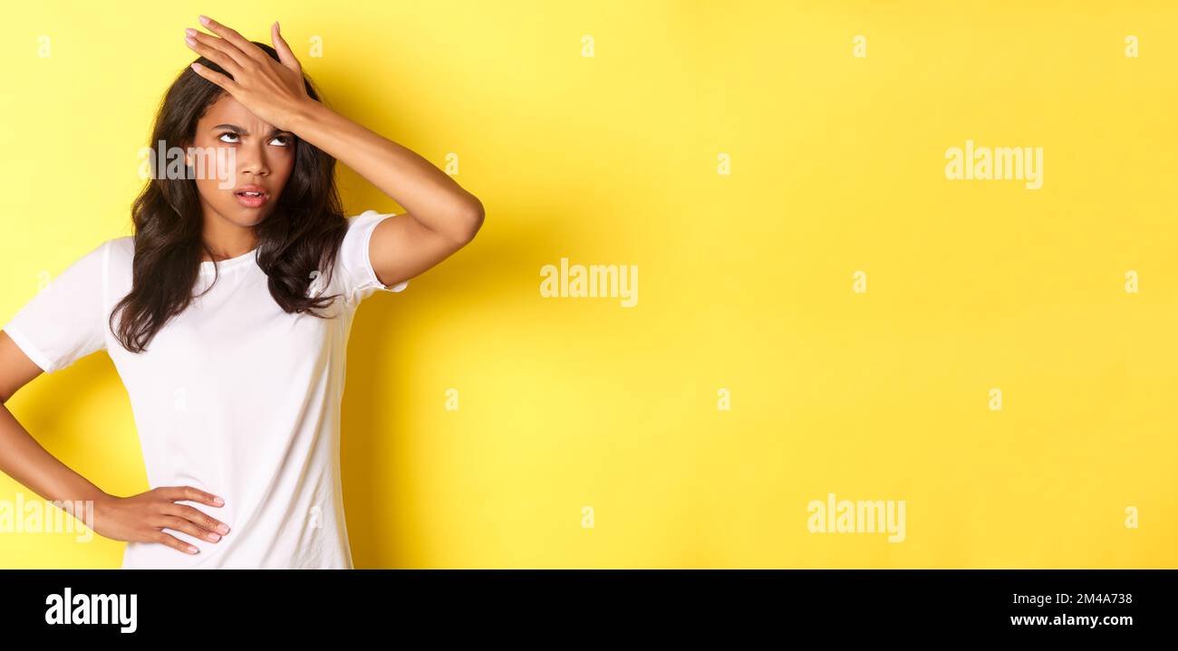 Portrait of annoyed african-american girl, slap forehead and roll her ...