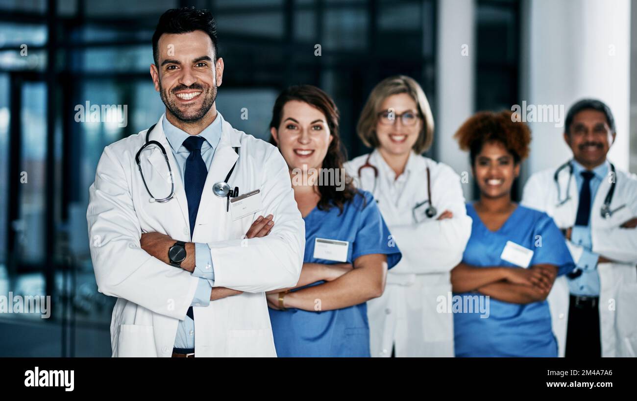 Were here for your healing. Portrait of a team of confident doctors standing together in a ...