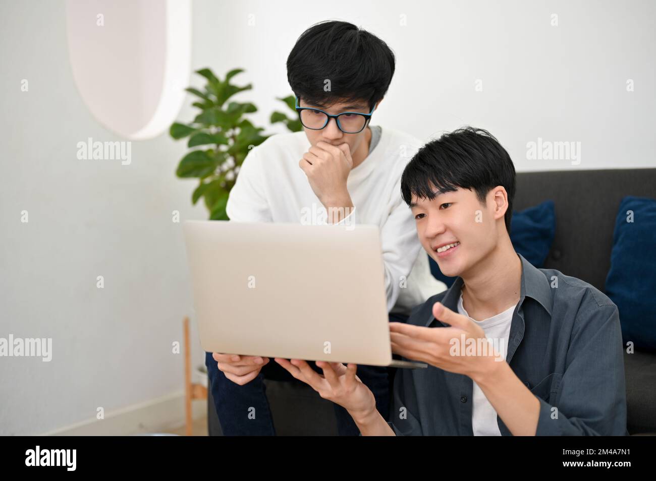Two of smart young Asian male college students doing school project ...