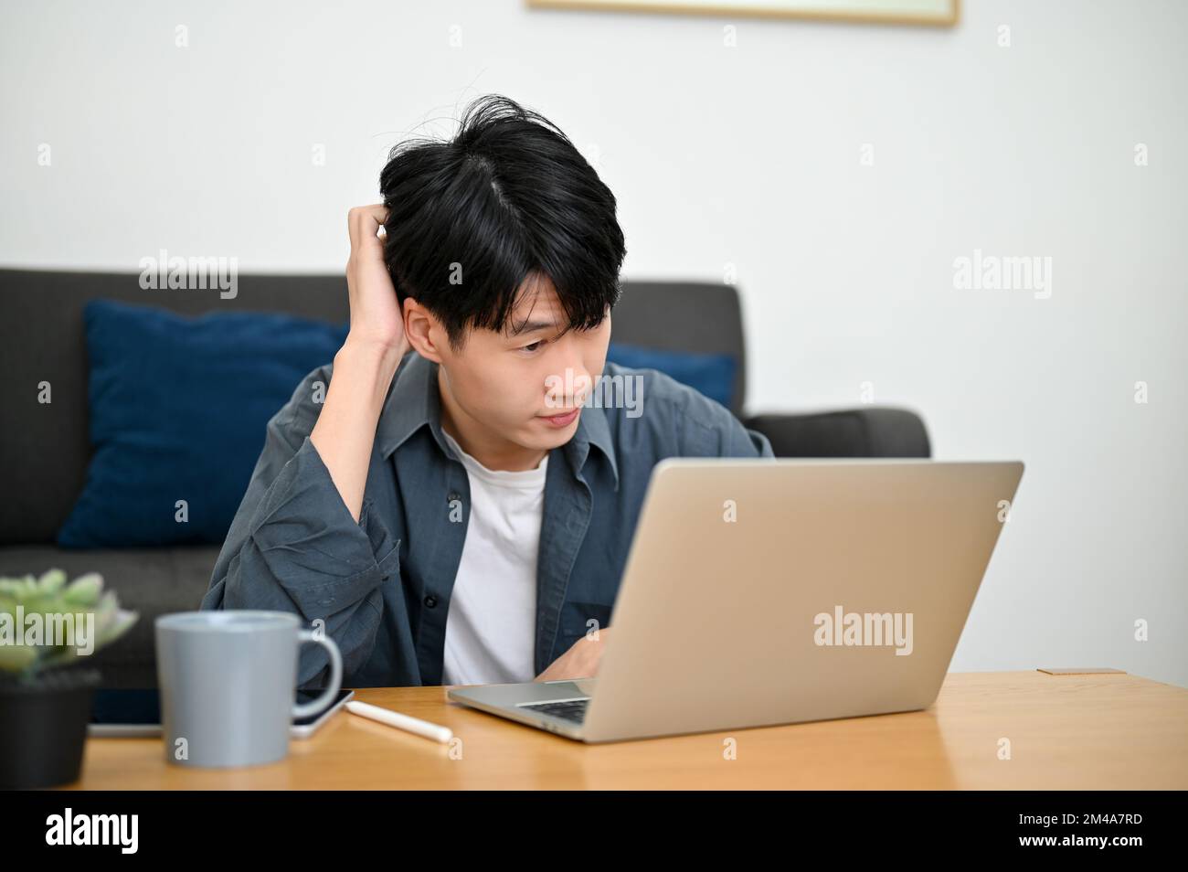 Confused young Asian man experiencing internet connection issues at ...