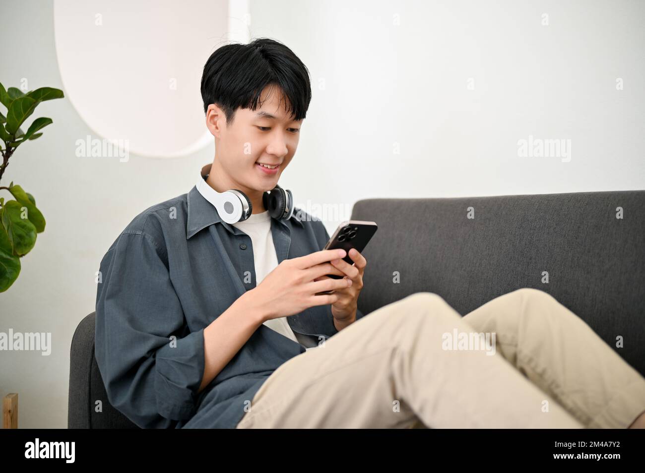 side view, Happy and relaxed young Asian man chatting with his friends ...