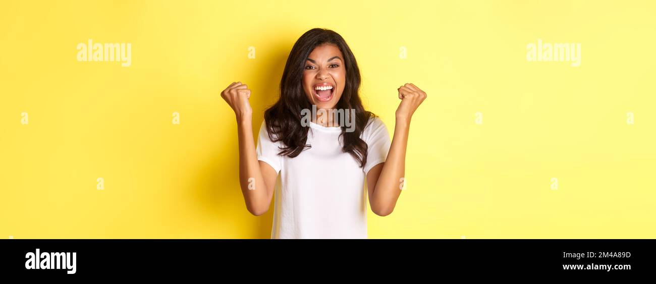 Image of successful african-american girl, feeling lucky, making fist ...
