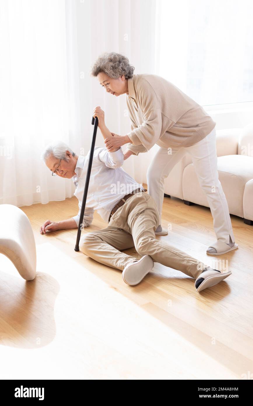 Senior Chinese woman helping her husband to get up Stock Photo - Alamy