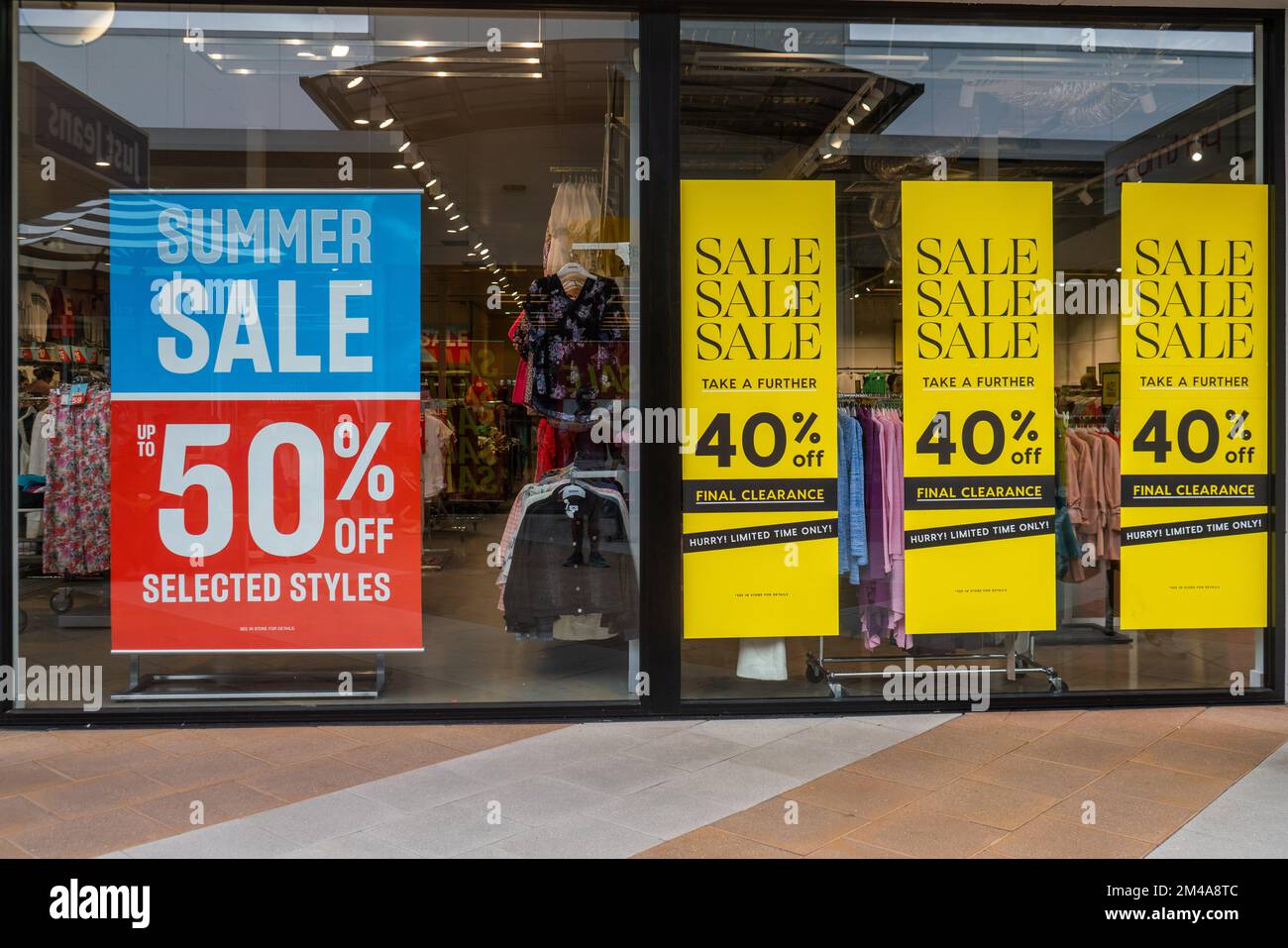 Sale signs in a shop window offering discounts Stock Photo - Alamy