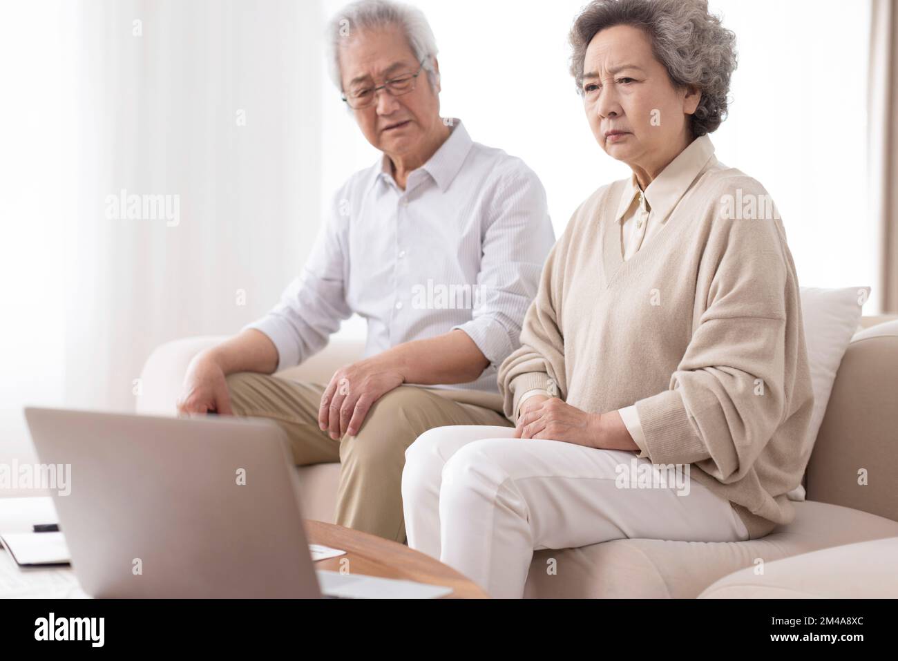 Senior Chinese couple arguing on sofa Stock Photo - Alamy