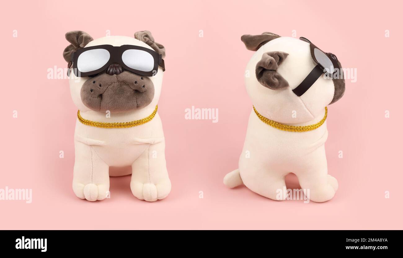 Two Plush soft beige pug dogs toys with sunglasses on pink background ...