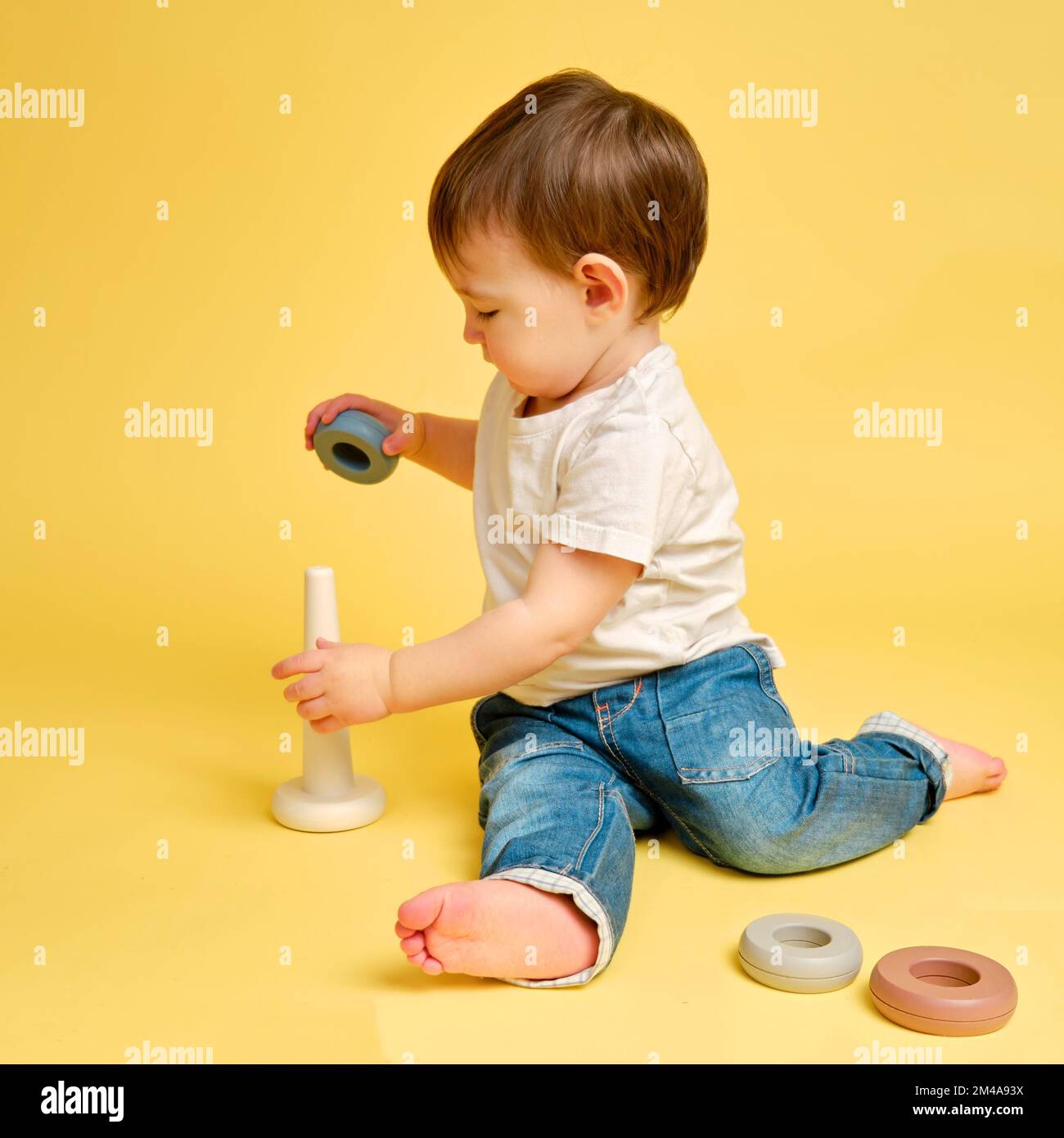 Toddler baby is playing logic educational games with a pyramid on a ...