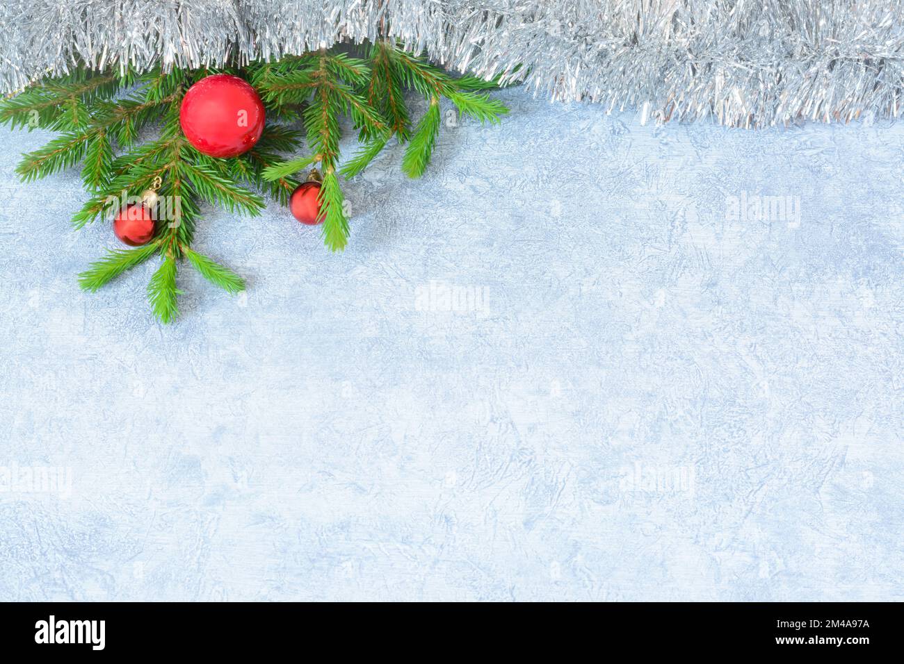 Gray background with fir branches, red christmas balls and garland with ...