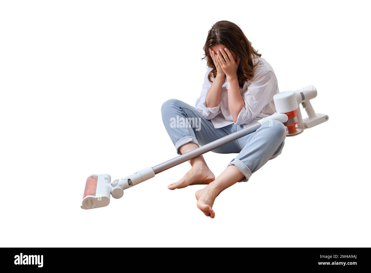 A crying woman with a wireless portable vacuum cleaner in the kitchen ...