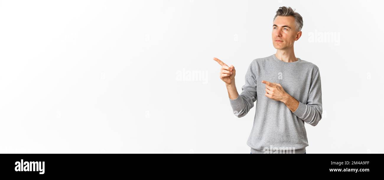 Image of thoughful handsome man, making decision, pointing and looking ...